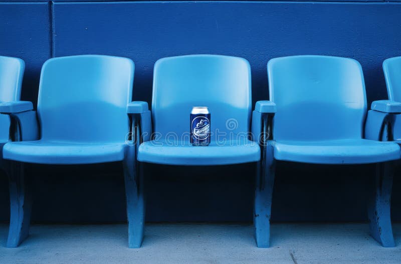 A Can of Beer Sits on a Blue Chair in a Row of Blue Chairs Stock ...