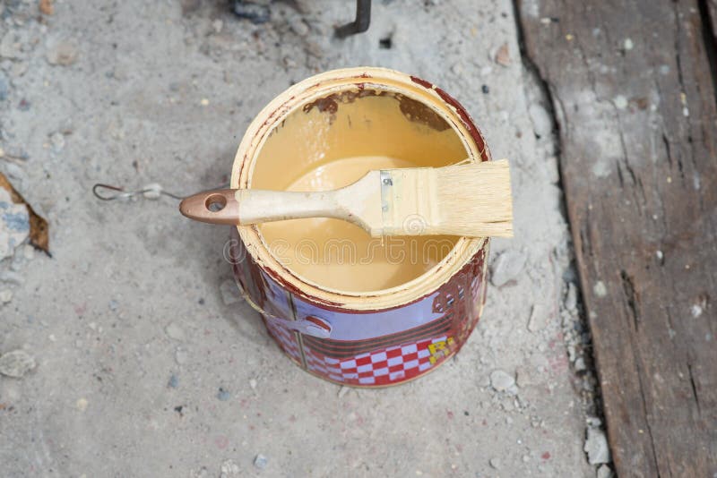 Can of Yellow Paint and Professional Brush on Ground Stock Image ...