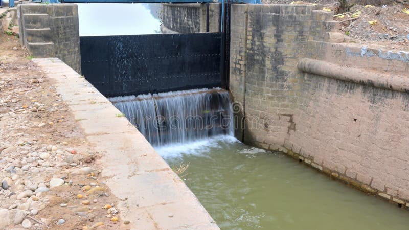 A Canal Lock Featuring a Black Metal Gate Regulates Water Flow. Stock ...