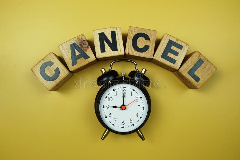 Cancel Word and Alarm Clock Top View on Yellow Background Stock Photo ...