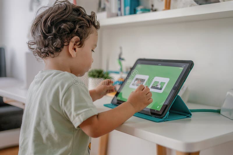 Candid Image of a Child Engaged in Interactive Learning on a Tablet ...