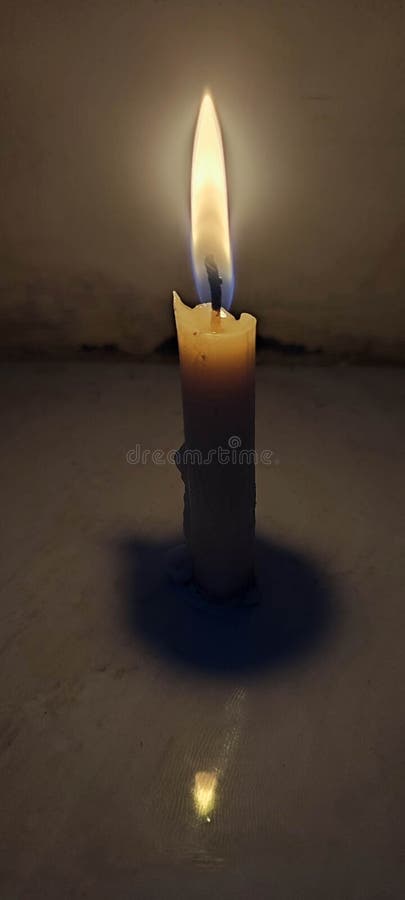 A Candle with a Burning Flame in Its Wick and a Small Flame Shadow ...