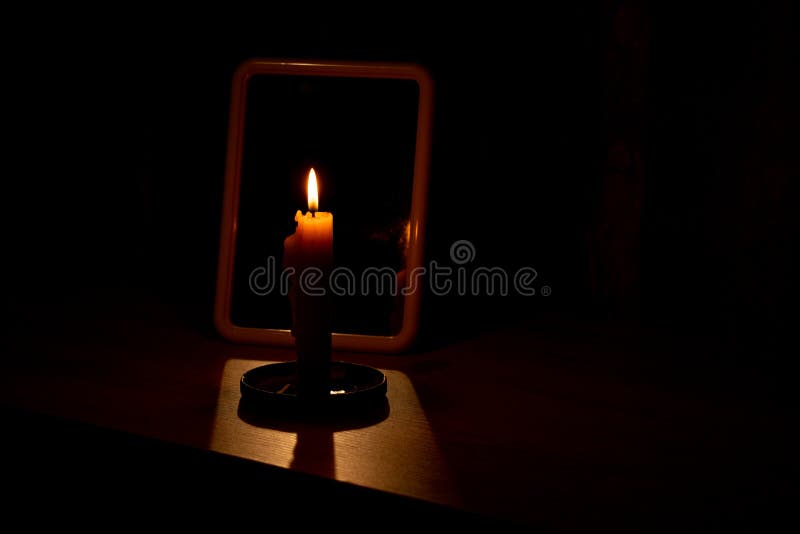 Candle Light in the Reflection of a Mirror Standing on a Table in a ...