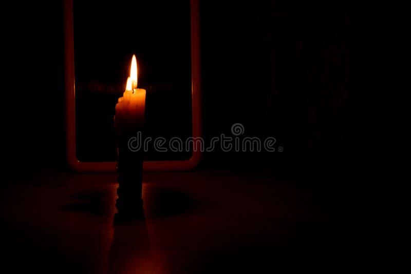 Candle Light in the Reflection of a Mirror Standing on a Table in a ...
