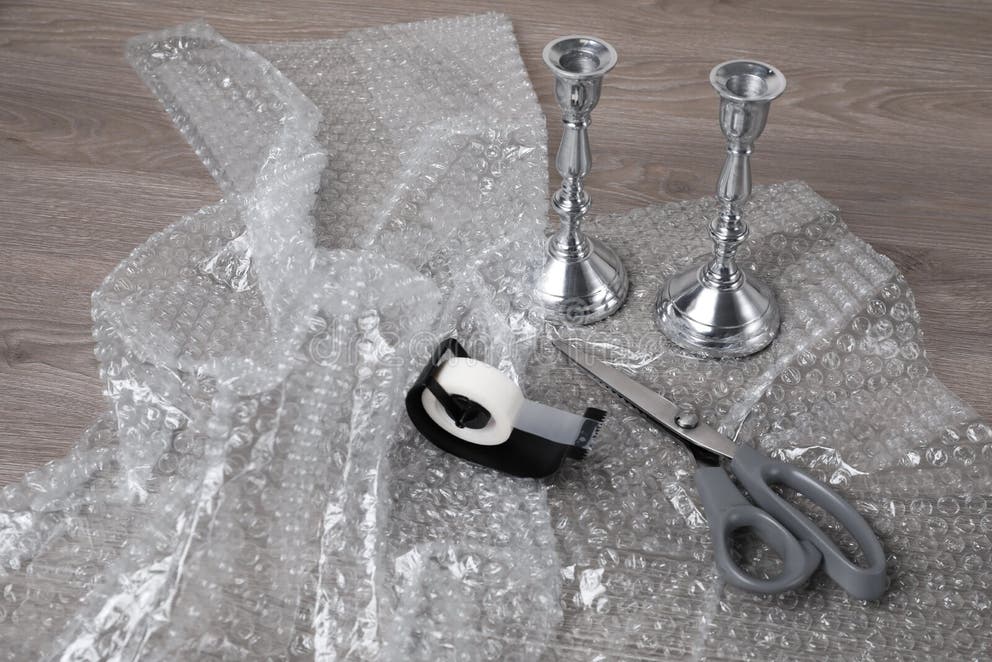 Candlesticks with Bubble Wrap, Adhesive Tape and Scissors on Wooden ...