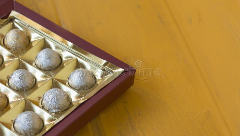 Candy in Silver Wrapper in Box on Yellow Background with Copy Space ...