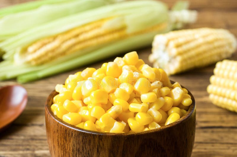 Canned Corn in a Wooden Plate and Cob of Fresh Corn on a Rustic Wooden ...