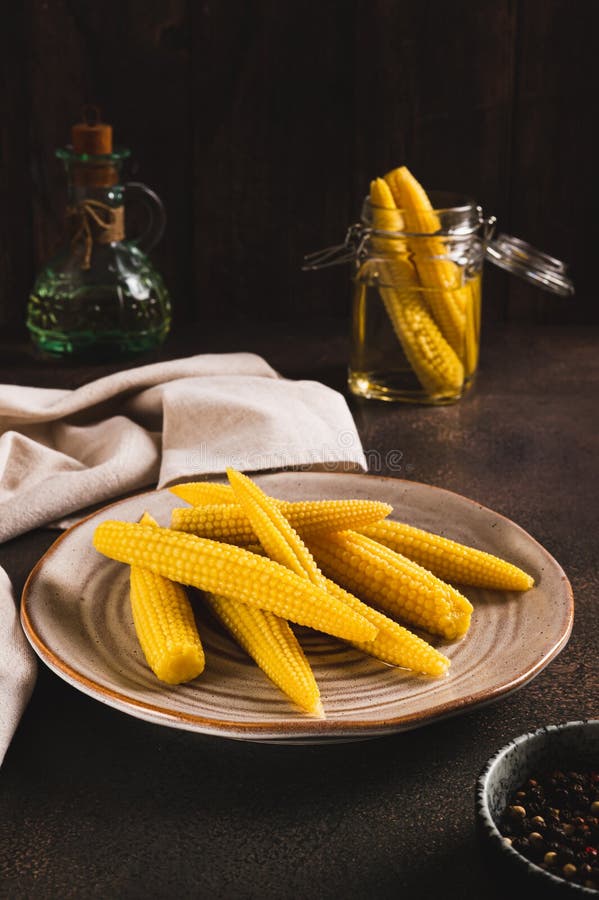 Canned Mini Corn Cobs on a Plate on a Table Vertical View Stock Photo ...
