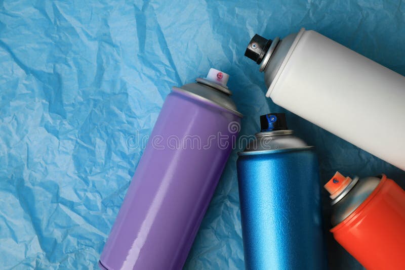Cans of Different Graffiti Spray Paints on Light Blue Crumpled Paper ...