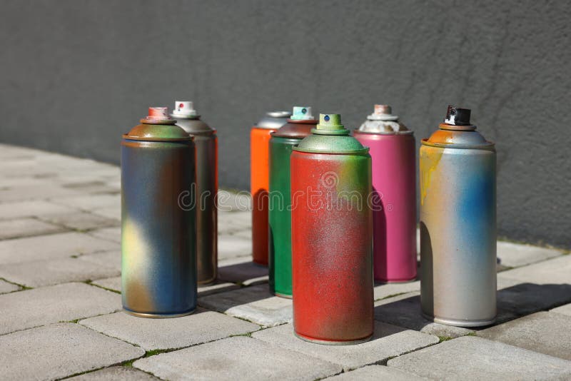 Cans of Different Spray Paints on Pavement Near Wall Stock Image ...