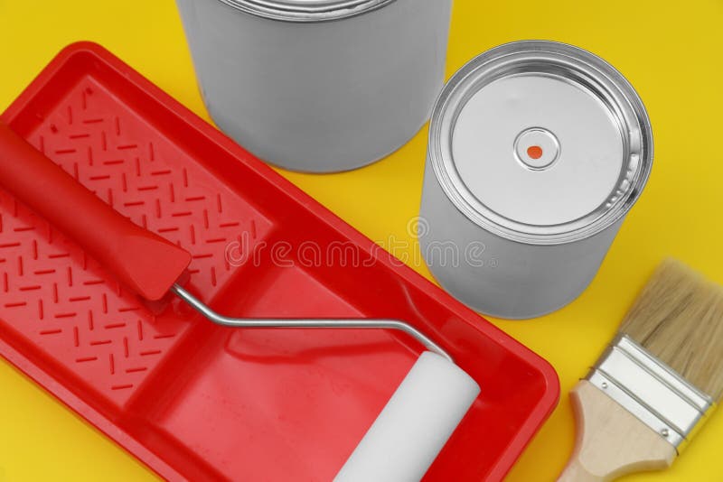 Cans of Orange Paint, Brush, Roller and Container on Yellow Background ...