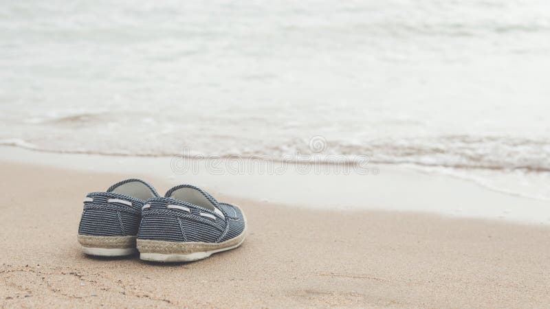 Canvas shoes on sand beach stock photo. Image of lonely - 60164838