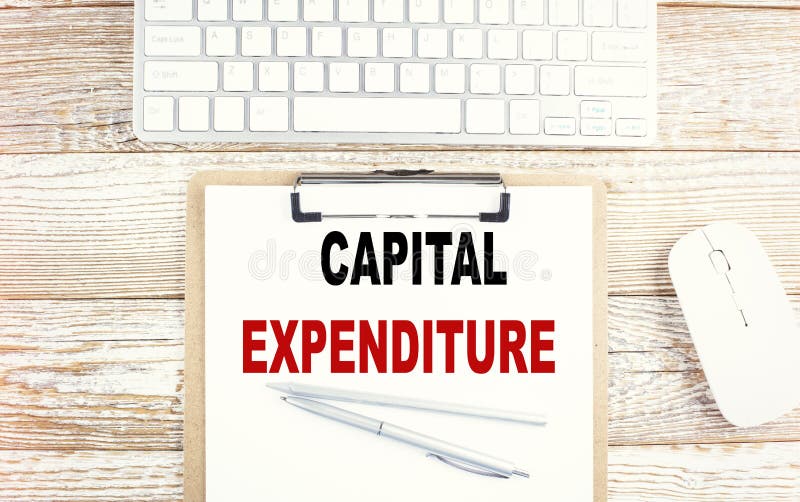 CAPITAL EXPENDITURE Text on a Clipboard with Keyboard on Wooden ...