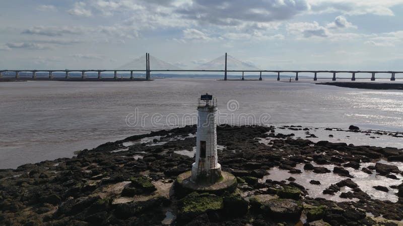 Camera Panning Around a White Lighthouse on a Rocky Island with a ...