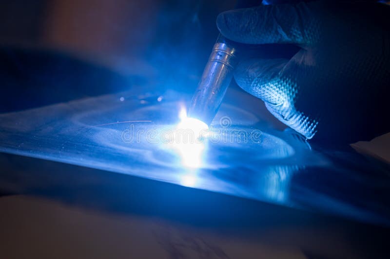 Close-up of a Welder S Gloved Hand Holding a Welding Tool, Emitting ...