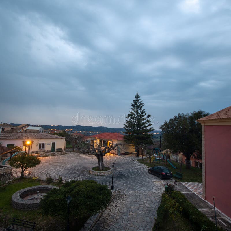Overcast Dusk Settles on a Quaint Village Square, Centered with Trees ...