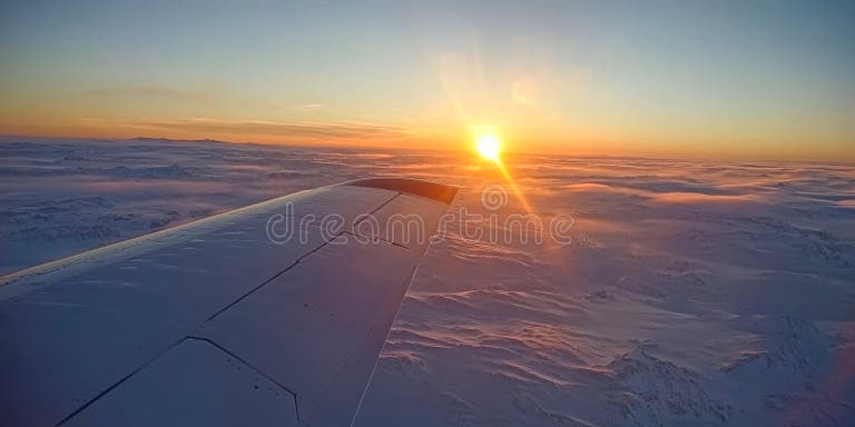 Capturing the Airplane Wing at Sunset Over Icy Terrain and Soft Clouds ...