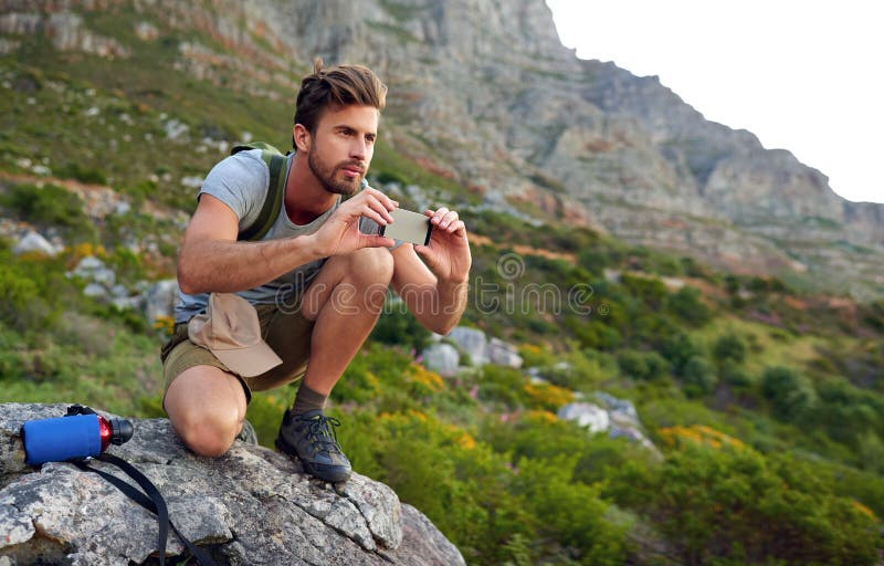 Capturing the Moment. a Handsome Young Man Snapping Pics while Hiking ...