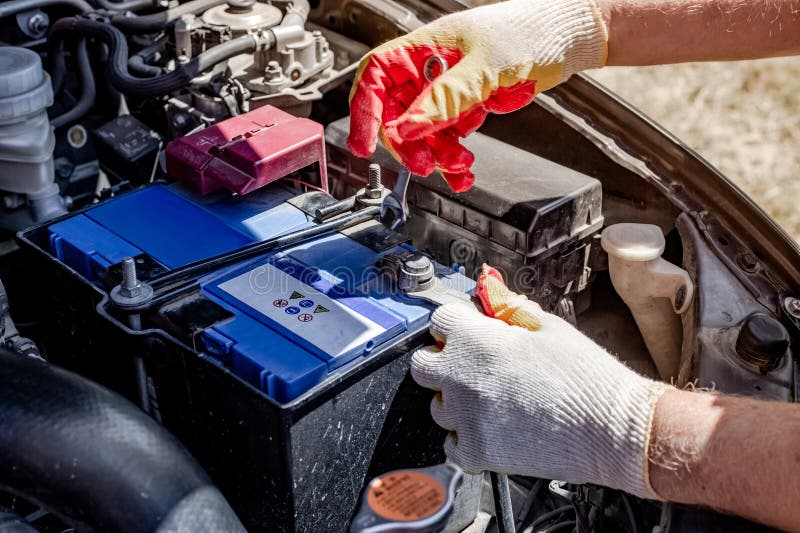 Car Battery Replacement. the Mechanic Removes the Terminals from the ...