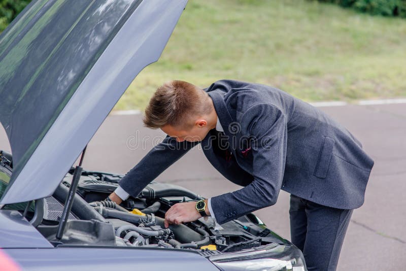 Car Breakdown. Concentrated Young Man Try To Repair the Engine, Stock ...