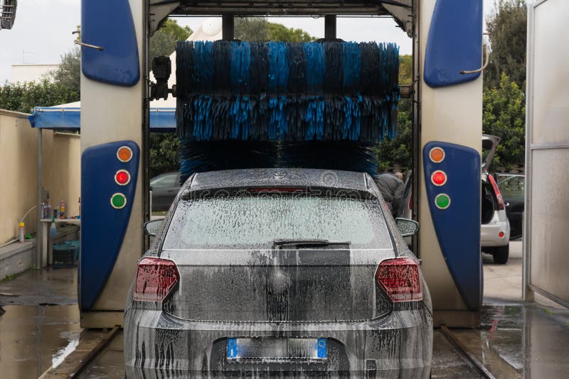 Car Covered by Active Foam during Car Washing Entering the Brushes of a ...