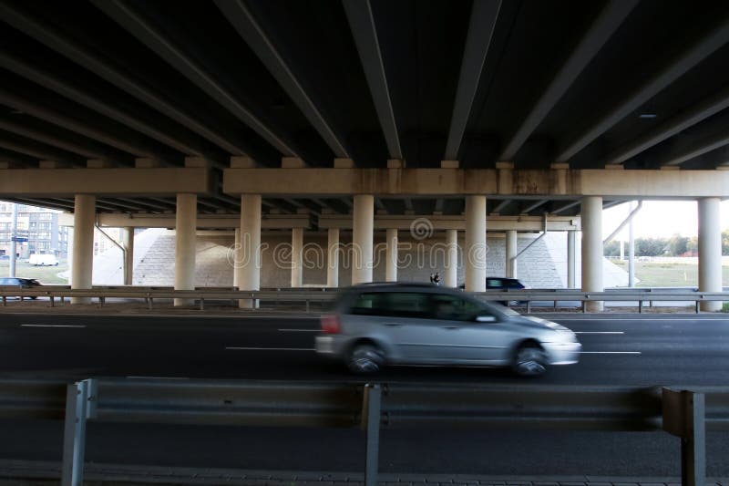 A Car is Currently Driving Smoothly Under a Bridge on a Highway Stock ...