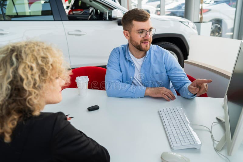 Car Dealership Manager with Client at Computer in Showroom. Stock Image ...