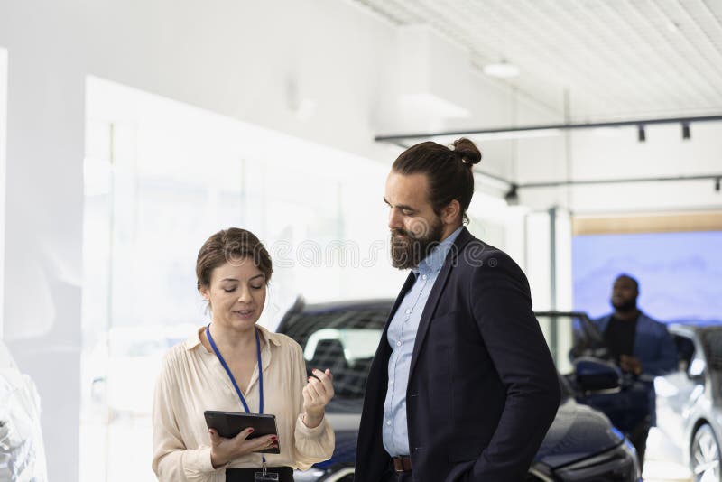 Car Dealership Salesman Providing Information Using Tablet Stock Photo ...