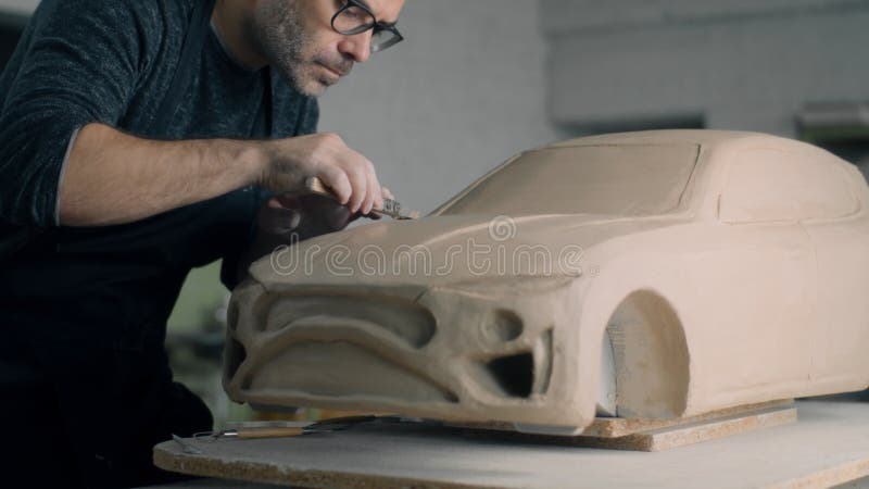 Car Designer Works on the Model of Car Using Shaping Tools To Smooth ...