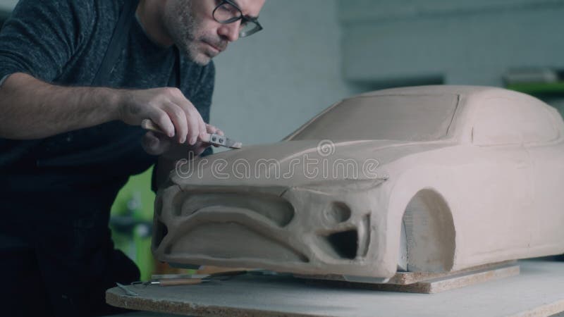 Car Designer Works on the Model of Car Using Shaping Tools To Smooth ...