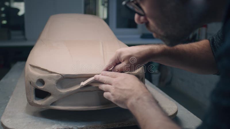 Car Designer Works on Prototype Car Using Shaping Tools To Create ...