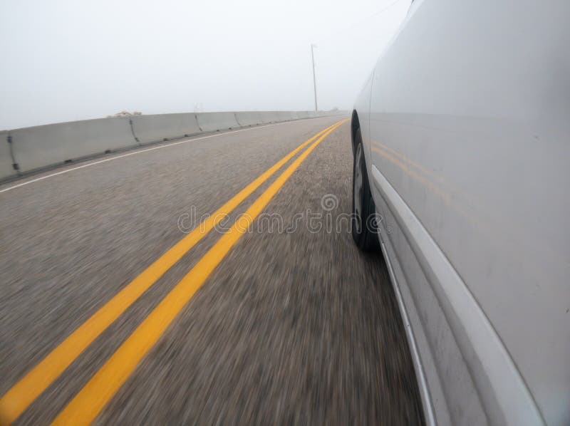 A Car is Driving Down a Road with Yellow Lines Stock Photo - Image of ...
