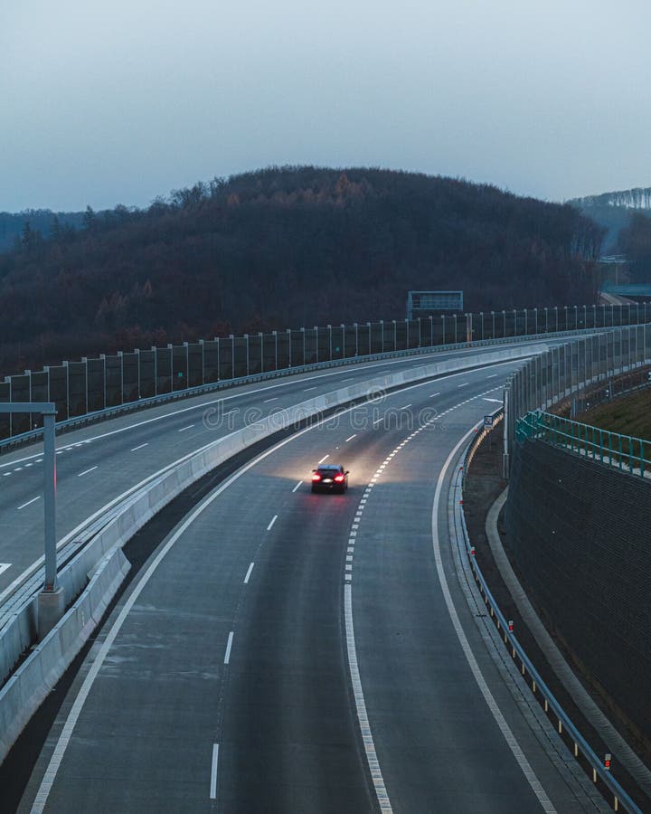 Car Driving on an Empty Highway with Lights on, Verticall Editorial ...