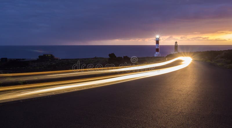 A Car Driving in Front of a Lighthouse at Sunset Stock Image - Image of ...