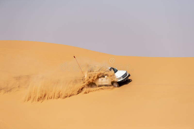 Car driving on sand dune stock photo. Image of dust - 213251816