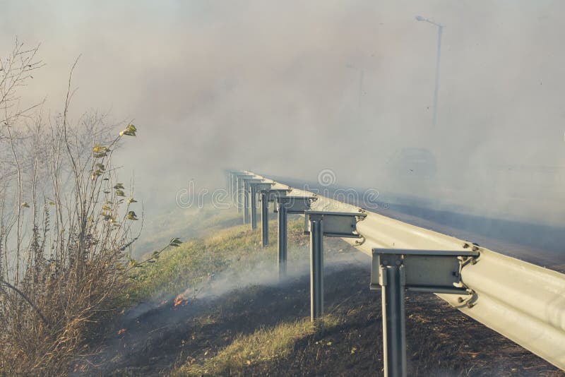 A Car Driving on a Suburban Highway during a Fire on the Side of the ...
