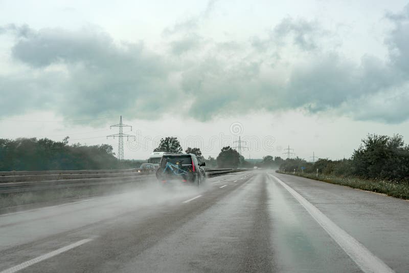 A Car on the Highway in the Rain Carries Bicycles in the Back of the ...