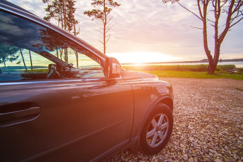 Car on the lake at sunrise stock photo. Image of clouds - 130914834