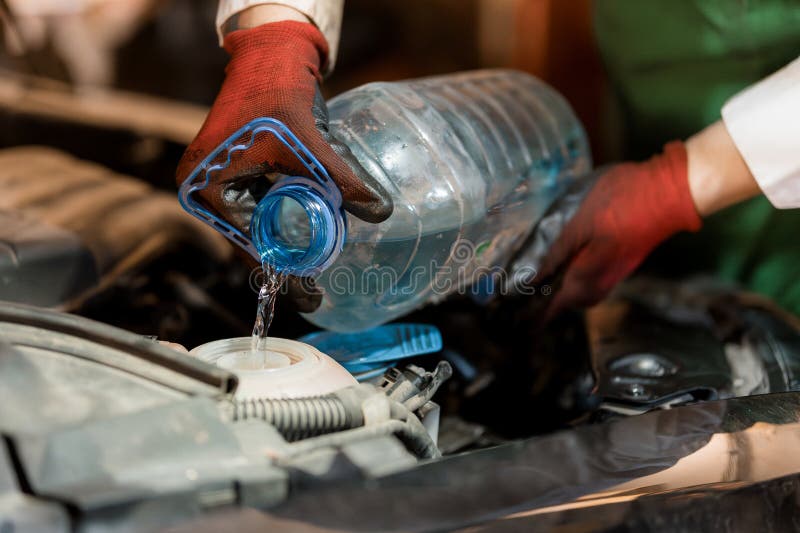 Car Maintenance: Filling Coolant from a Plastic Bottle into an Engine ...