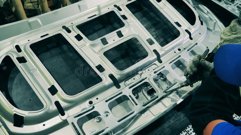 Car Manufacturing Worker Using Adhesive at a Car Production Line Stock ...