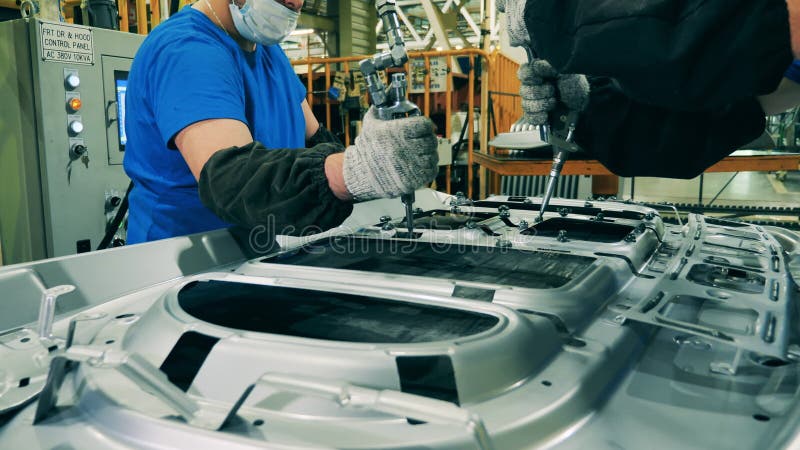 Car Manufacturing Workers Using Structural Adhesive at a Car Factory ...