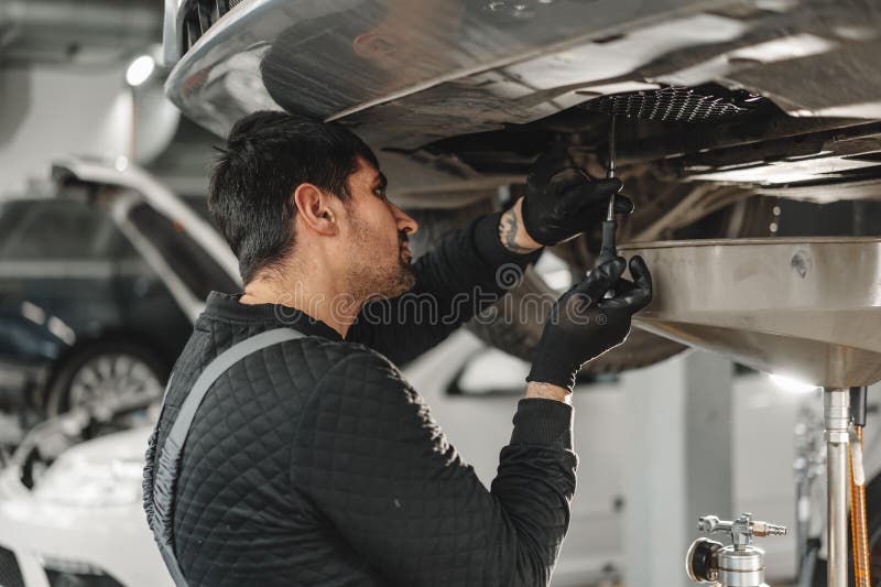Car Mechanic Changing Oil in a Car Service Stock Image - Image of ...