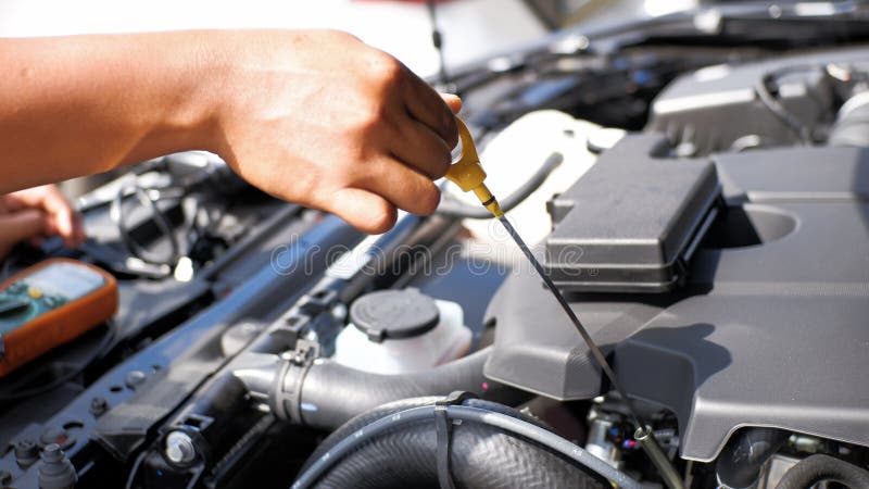 Car Mechanic Checking Car Engine Oil Level and Car Engine Oil Quality ...