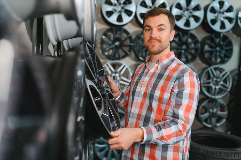 Car Mechanic Holding Car Rims Ready To Mount the Wheels in Workshop ...
