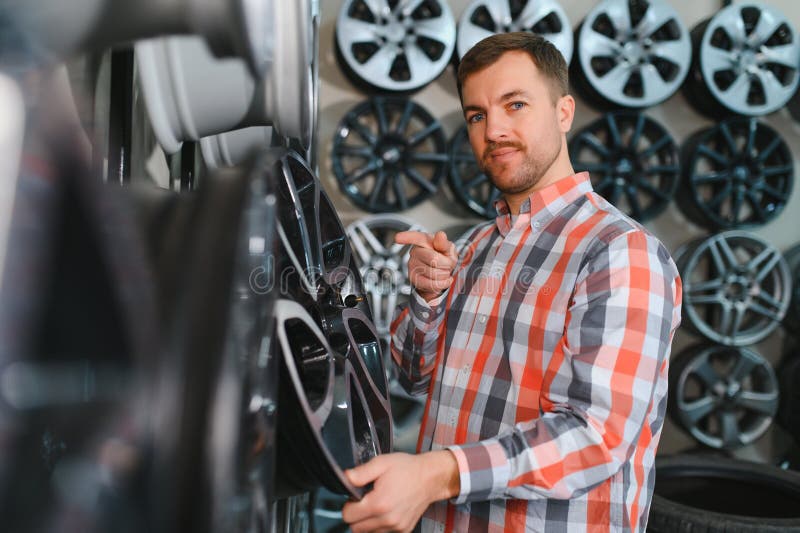 Car Mechanic Holding Car Rims Ready To Mount the Wheels in Workshop ...