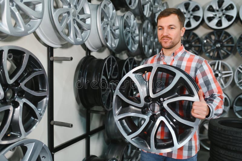 Car Mechanic Holding Car Rims Ready To Mount the Wheels in Workshop ...