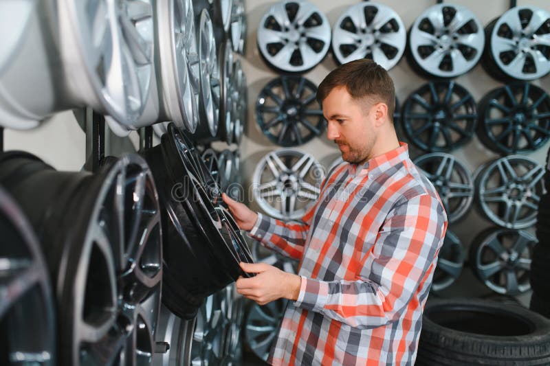 Car Mechanic Holding Car Rims Ready To Mount the Wheels in Workshop ...