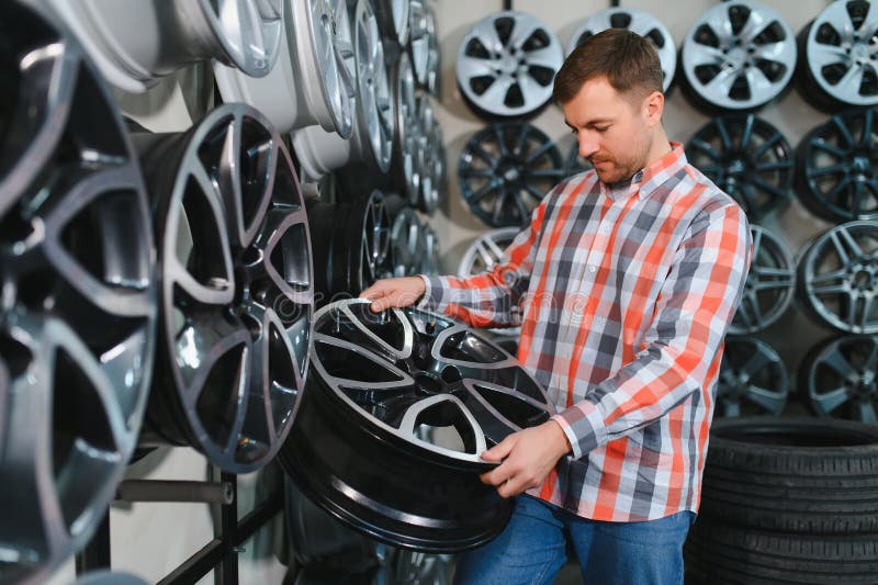 Car Mechanic Holding Car Rims Ready To Mount the Wheels in Workshop ...