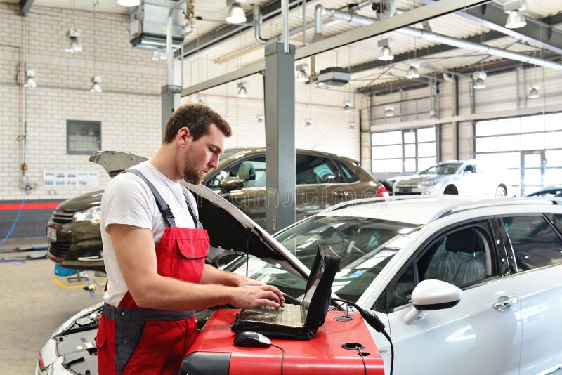 Car Mechanic Inspects Vehicle in a Workshop - Electronic Computer Check ...