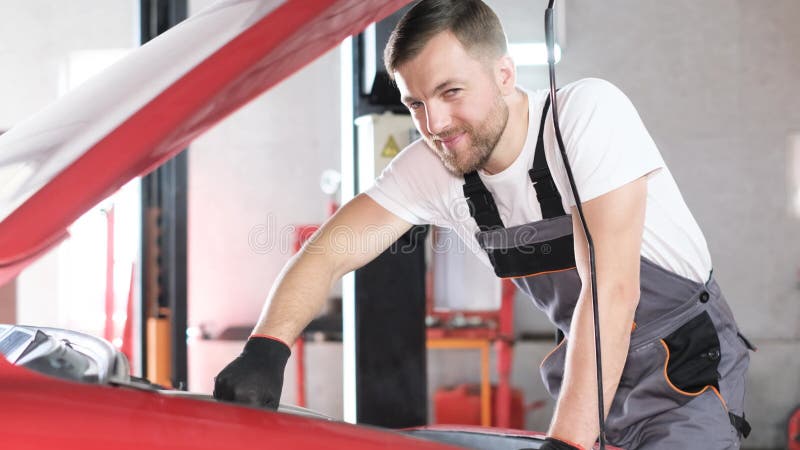 Car Mechanic in Uniform. Auto Repair Service.a Mechanic Checks a Car ...